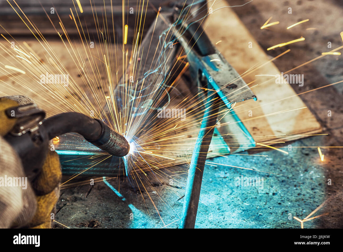 Close-up of a man welds a metal welding machine, sideways flying sparks ...