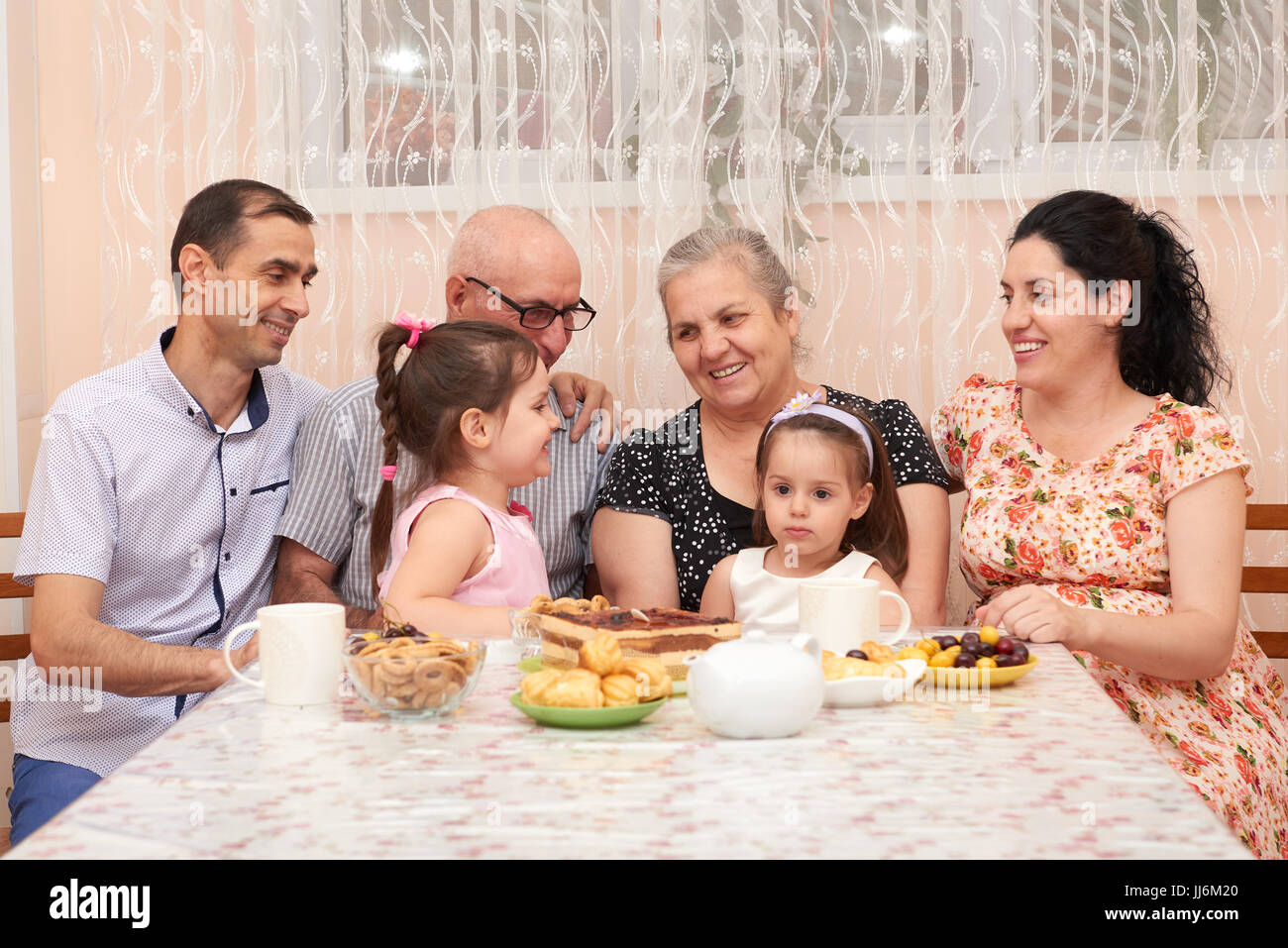big family drinking tea in dining room Stock Photo - Alamy