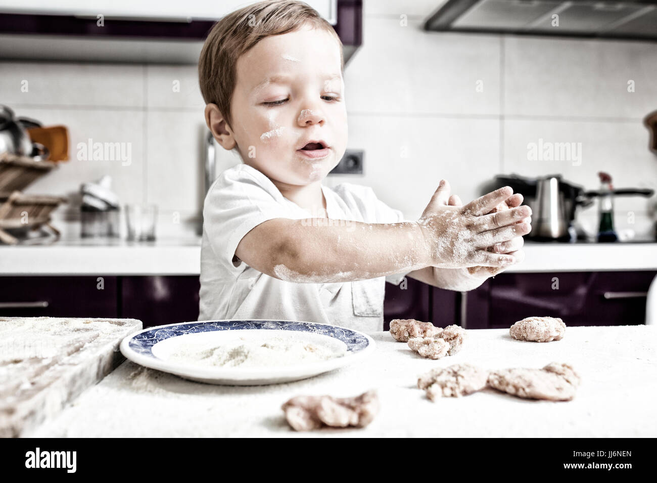 Baby boy preparing meatballs. He is kneading the balls Stock Photo - Alamy