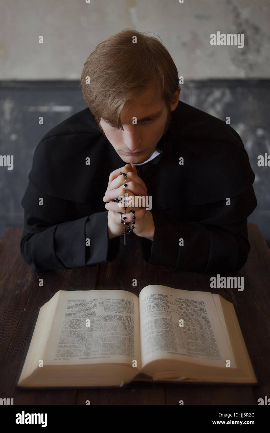 Young priest reading bible hi-res stock photography and images - Alamy