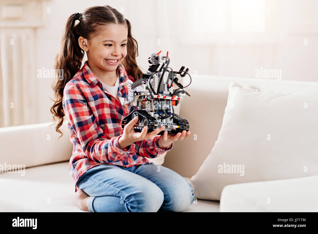 Delighted girl playing with robot Stock Photo - Alamy
