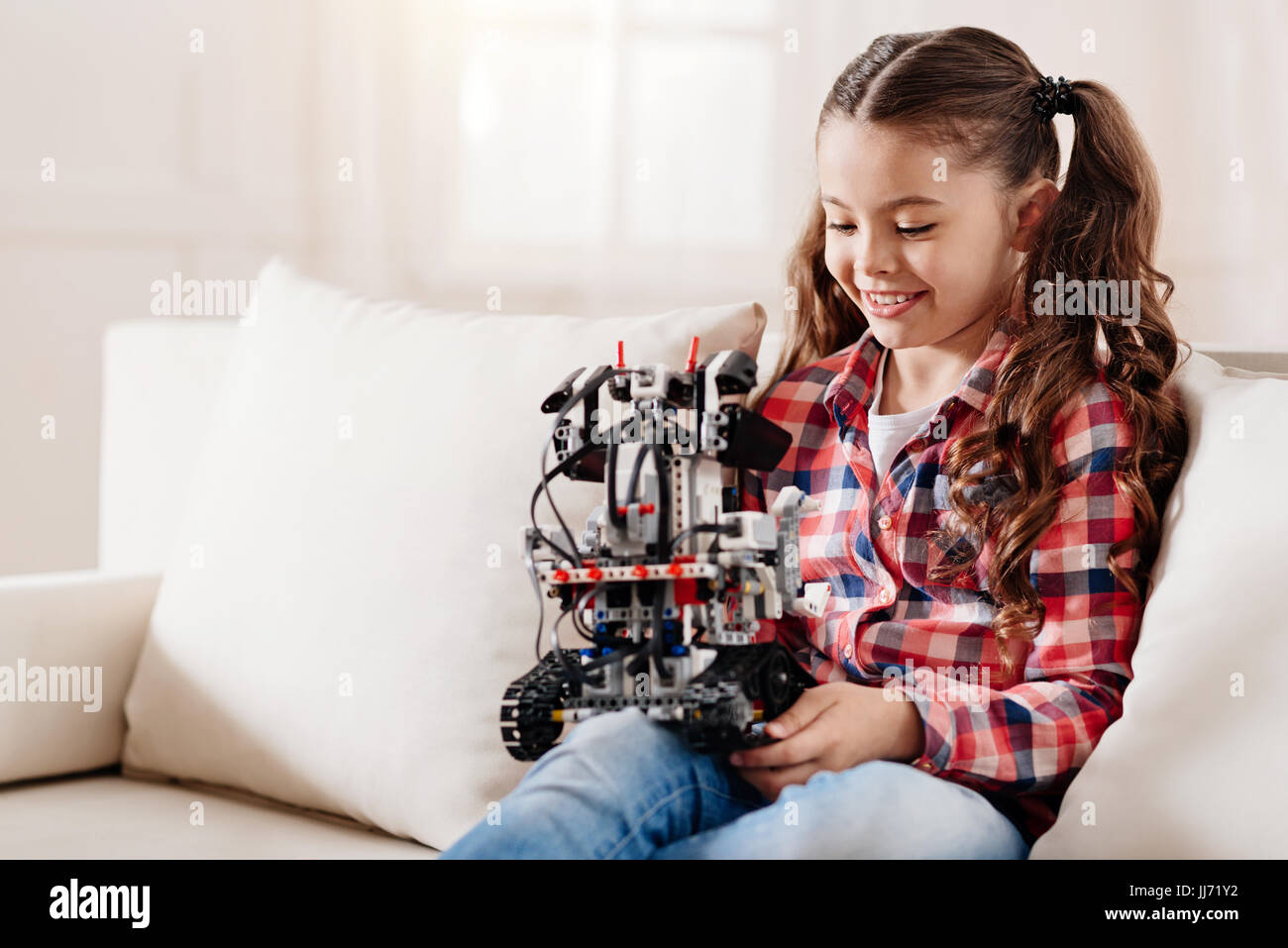 Delighted little female keeping her robot in both hands Stock Photo - Alamy