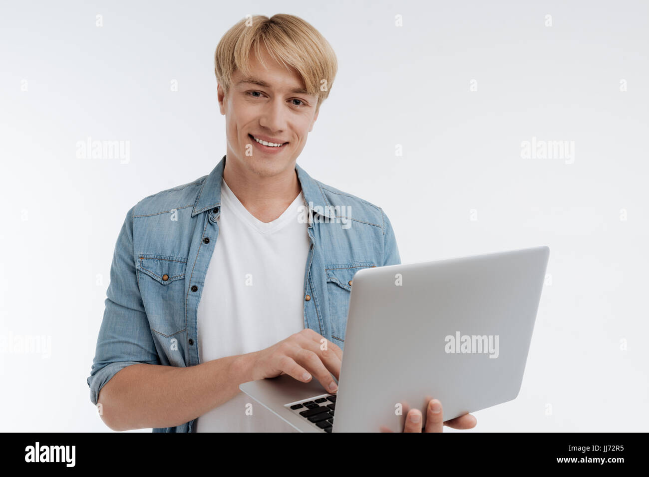 Handsome man posing on camera with laptop Stock Photo - Alamy