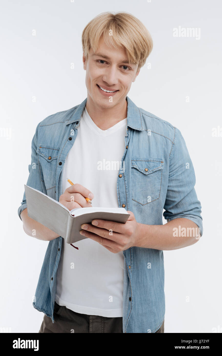 Handsome student holding notebook in left hand Stock Photo - Alamy