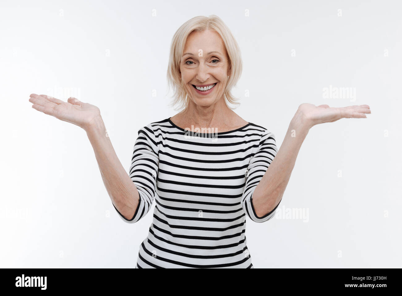 Happy female raising both arms upwards Stock Photo - Alamy