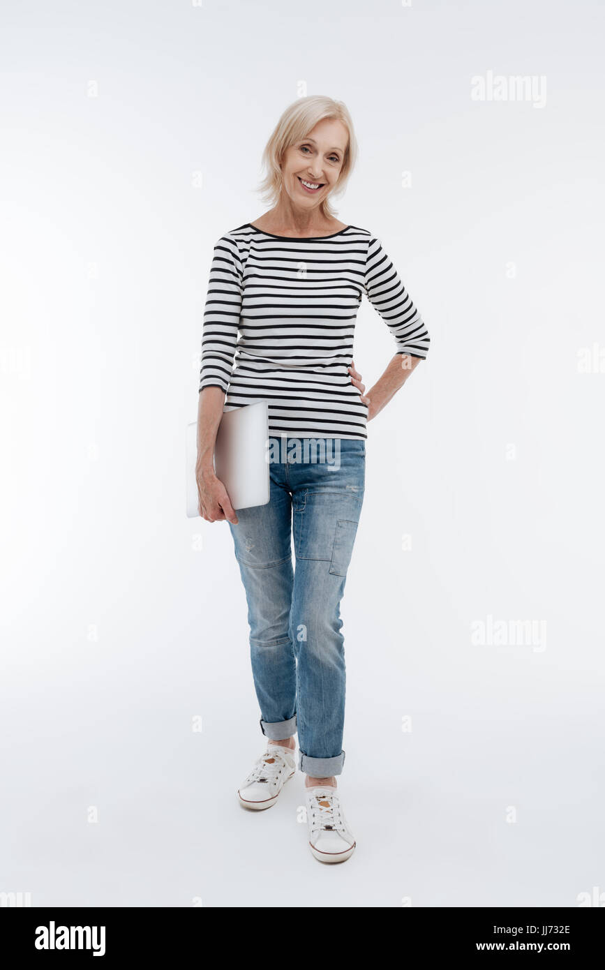 Delighted retired female putting her left hand on the waist Stock Photo ...