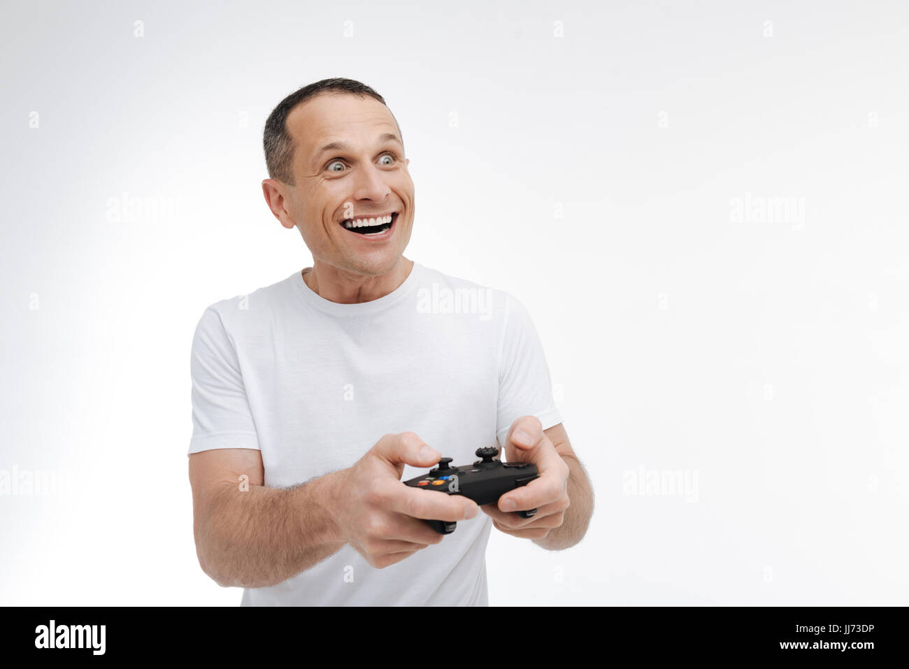 Infatuated male person playing with game console Stock Photo - Alamy