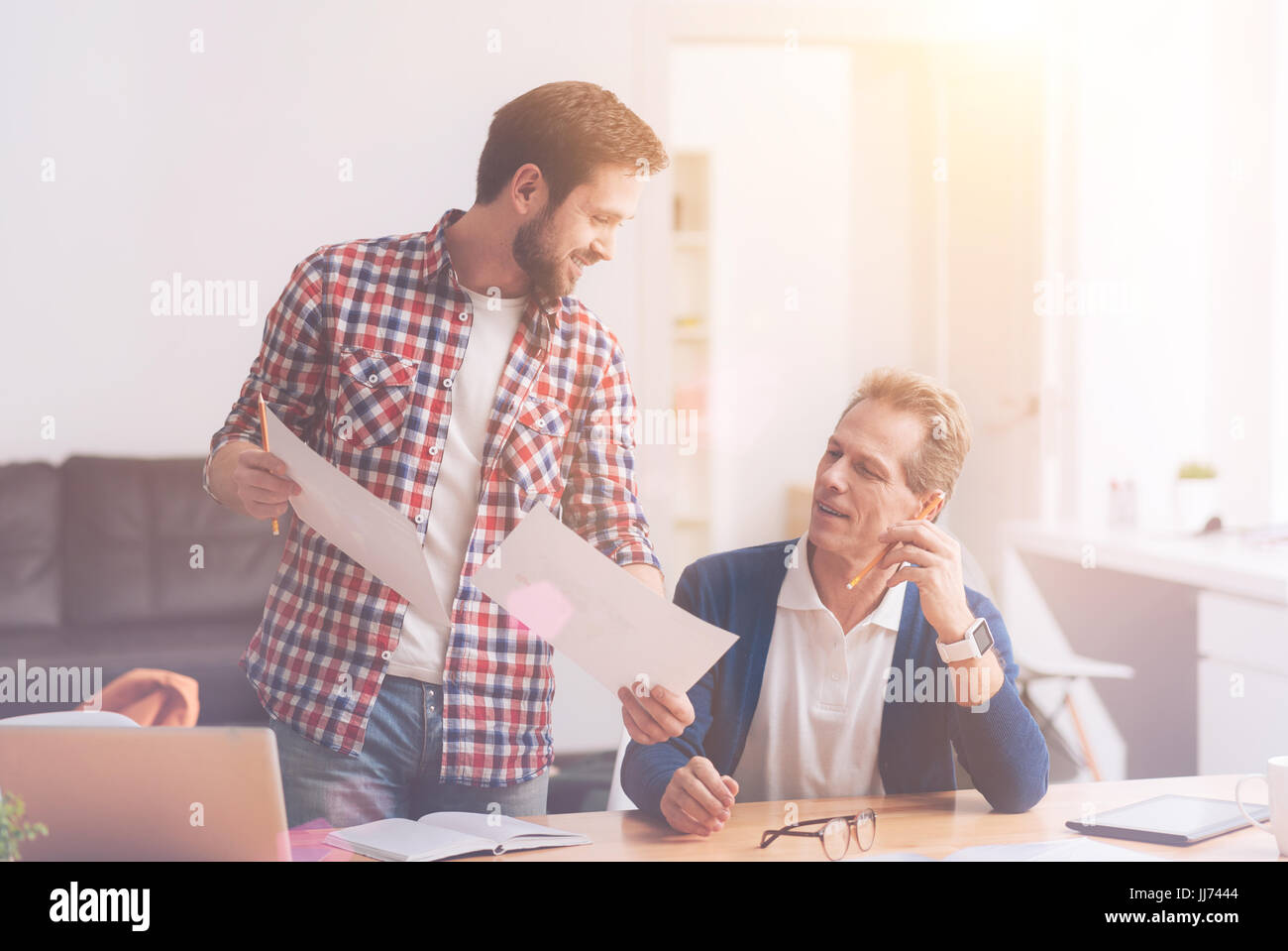 Positive colleagues helping each other in the office Stock Photo - Alamy