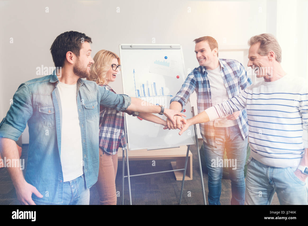 Positive colleagues showing common spirit Stock Photo - Alamy