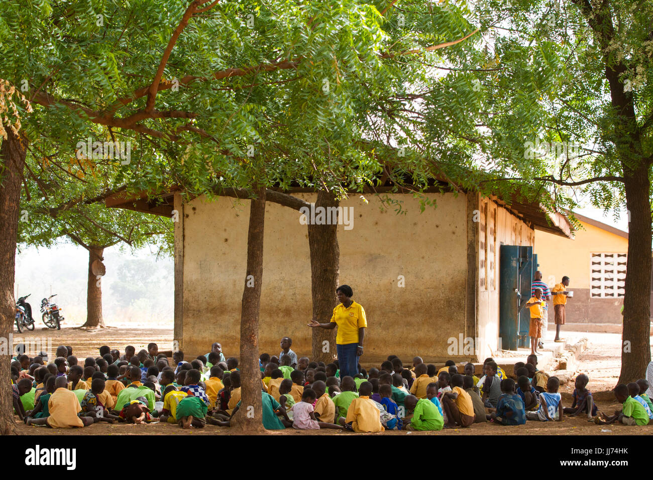 A volunteer teacher takes a large class of infants from the ...
