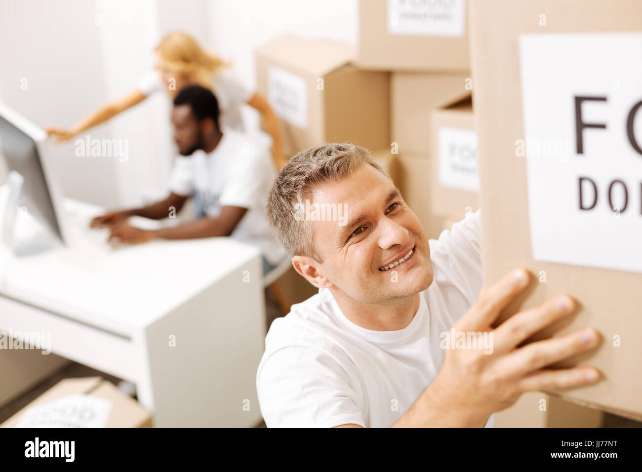 Charming productive man moving the boxes with supplies Stock Photo - Alamy