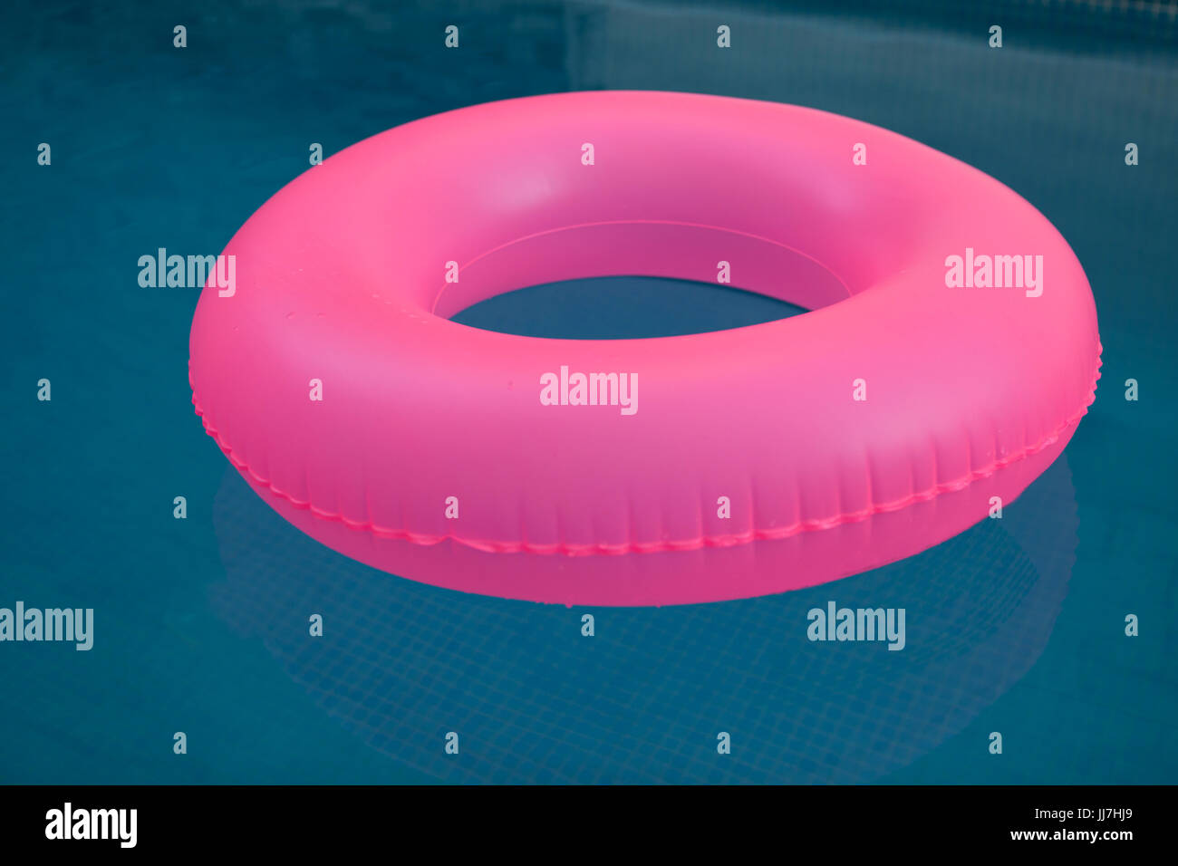 Pink float on a pool with crystal clear water Stock Photo - Alamy