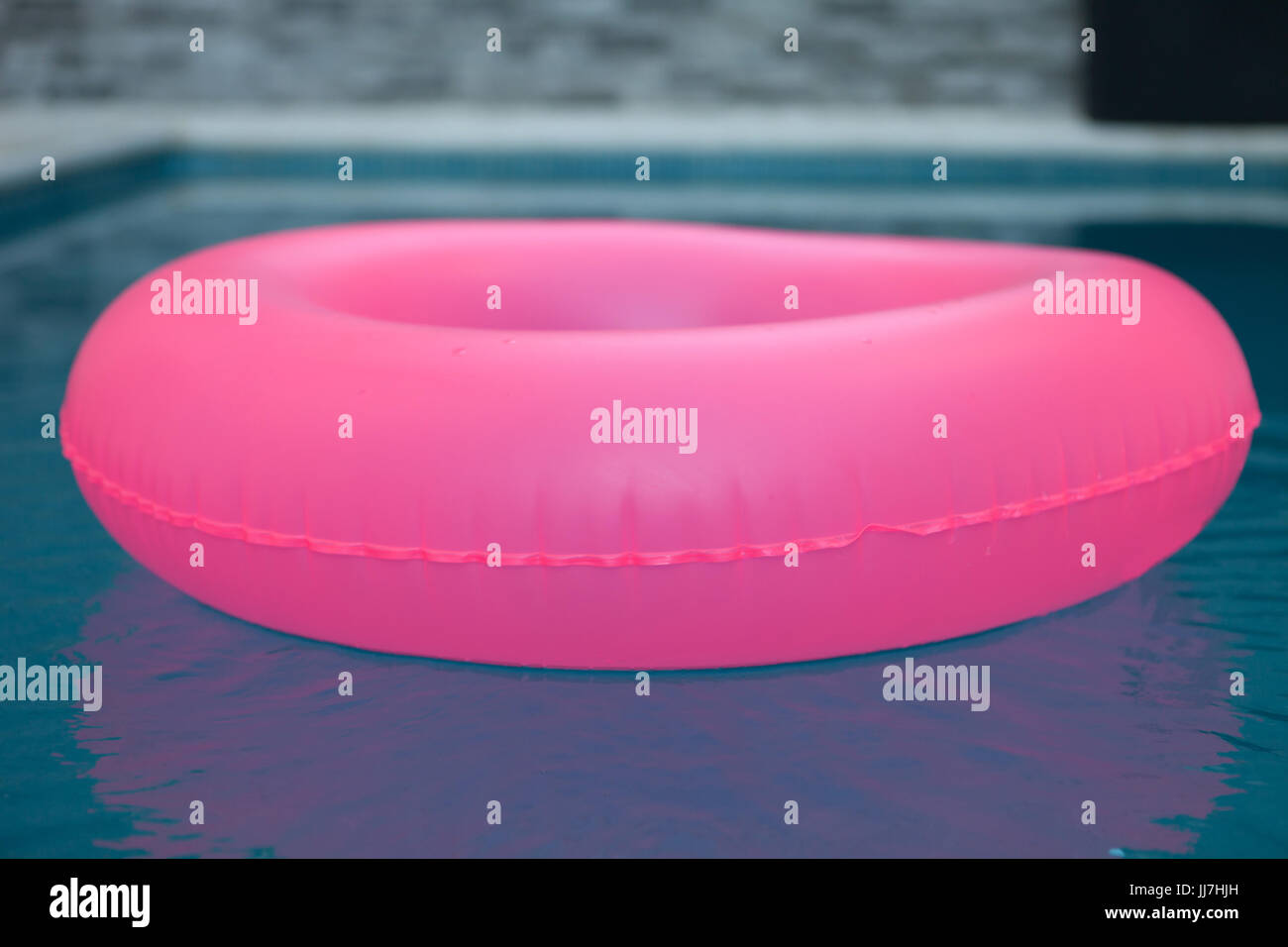 Pink float on a pool with crystal clear water Stock Photo - Alamy