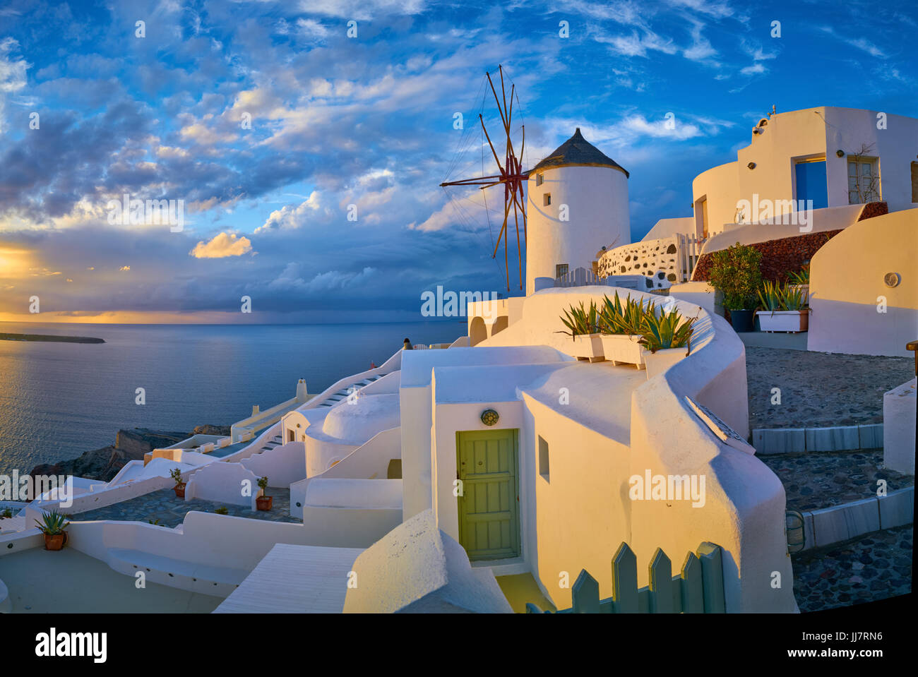Windmill in the village of Oia at sunset, Santorini, Greece Stock Photo ...