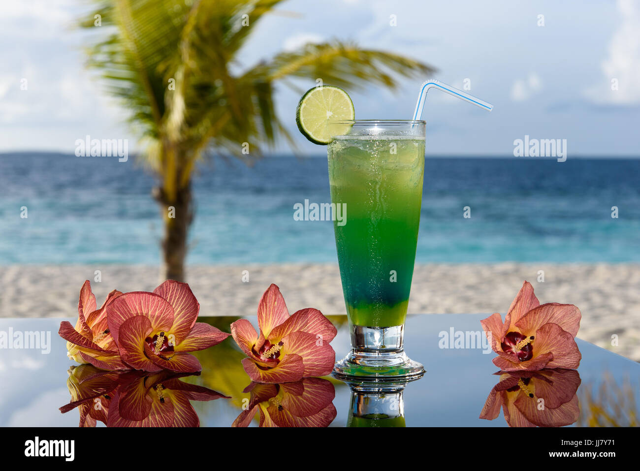 Green cocktail with flowers in a beach Stock Photo - Alamy
