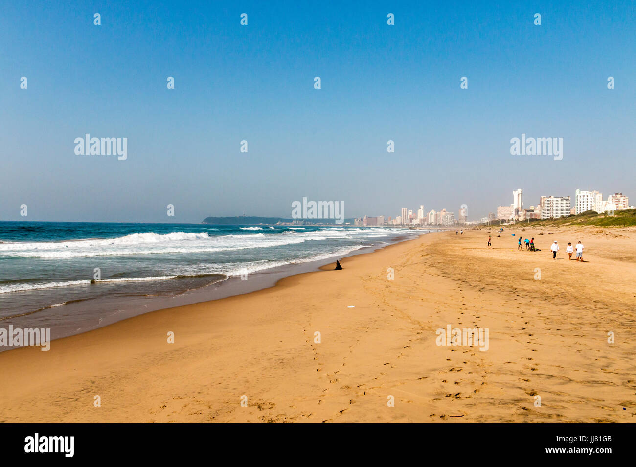 Morning coastal beach and ocean against distant blue Durban city ...
