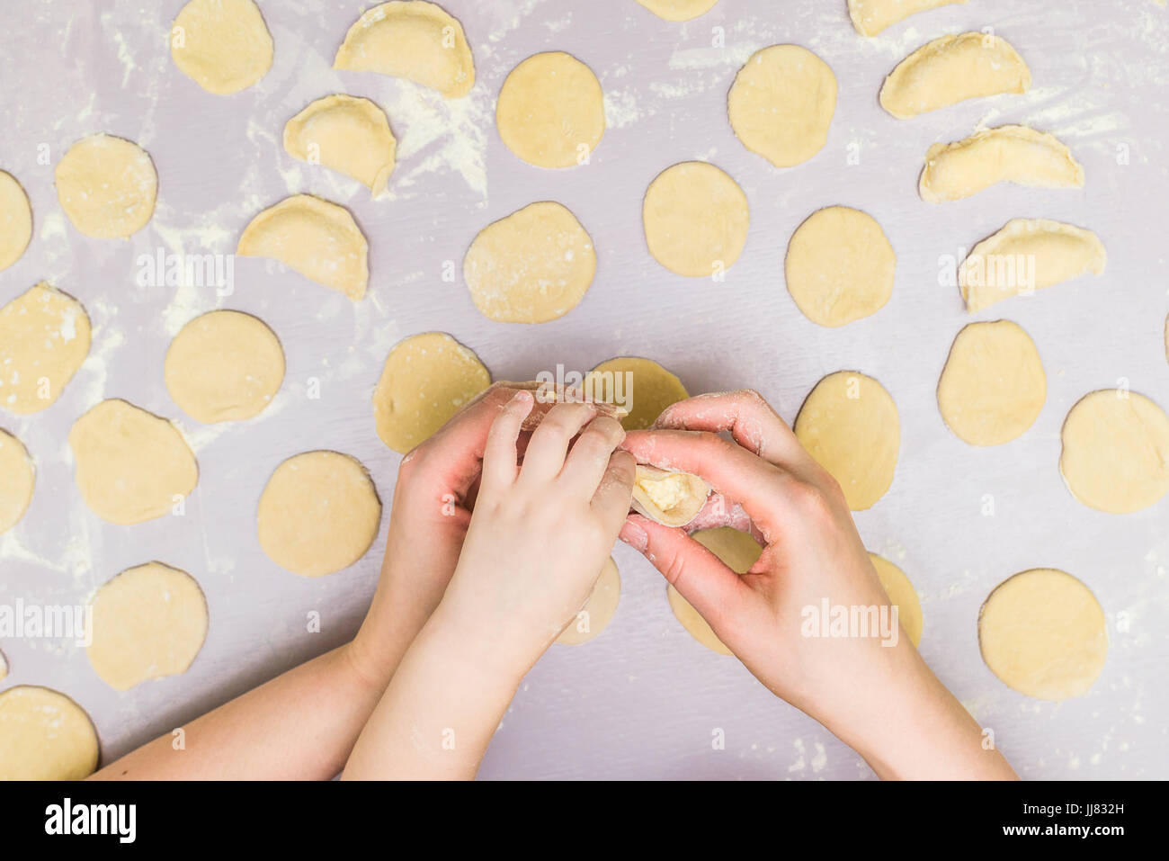 Mother and child hand's make ravioli Stock Photo - Alamy