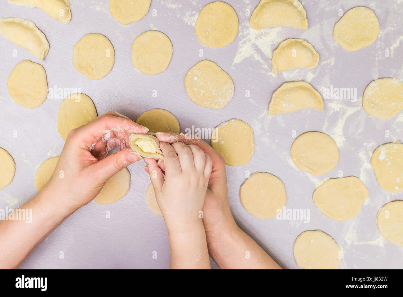Mother and child hand's make ravioli Stock Photo - Alamy