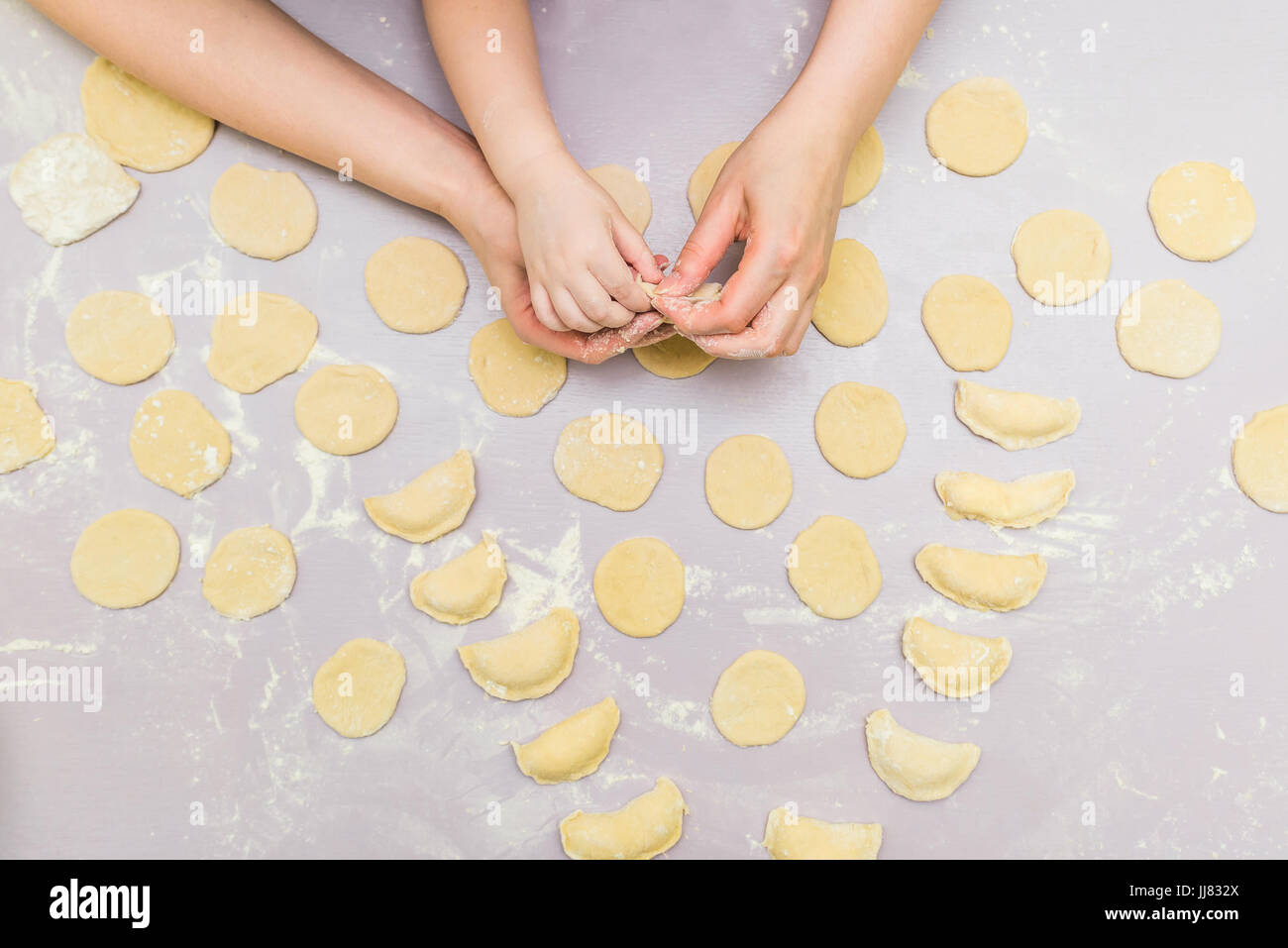 Mother and child hand's make ravioli Stock Photo - Alamy