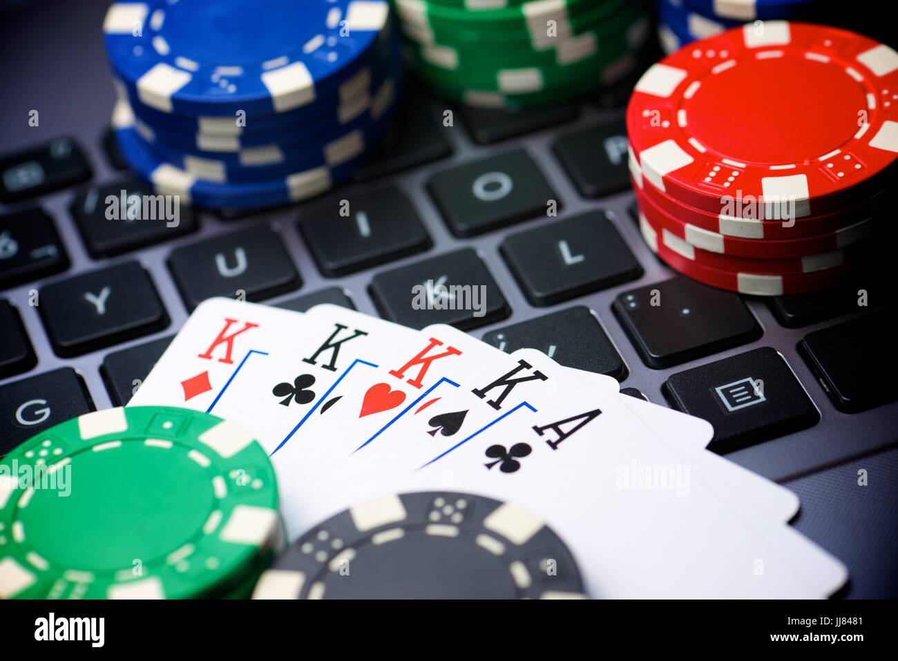Casino chips and cards stacking on a laptop Stock Photo - Alamy