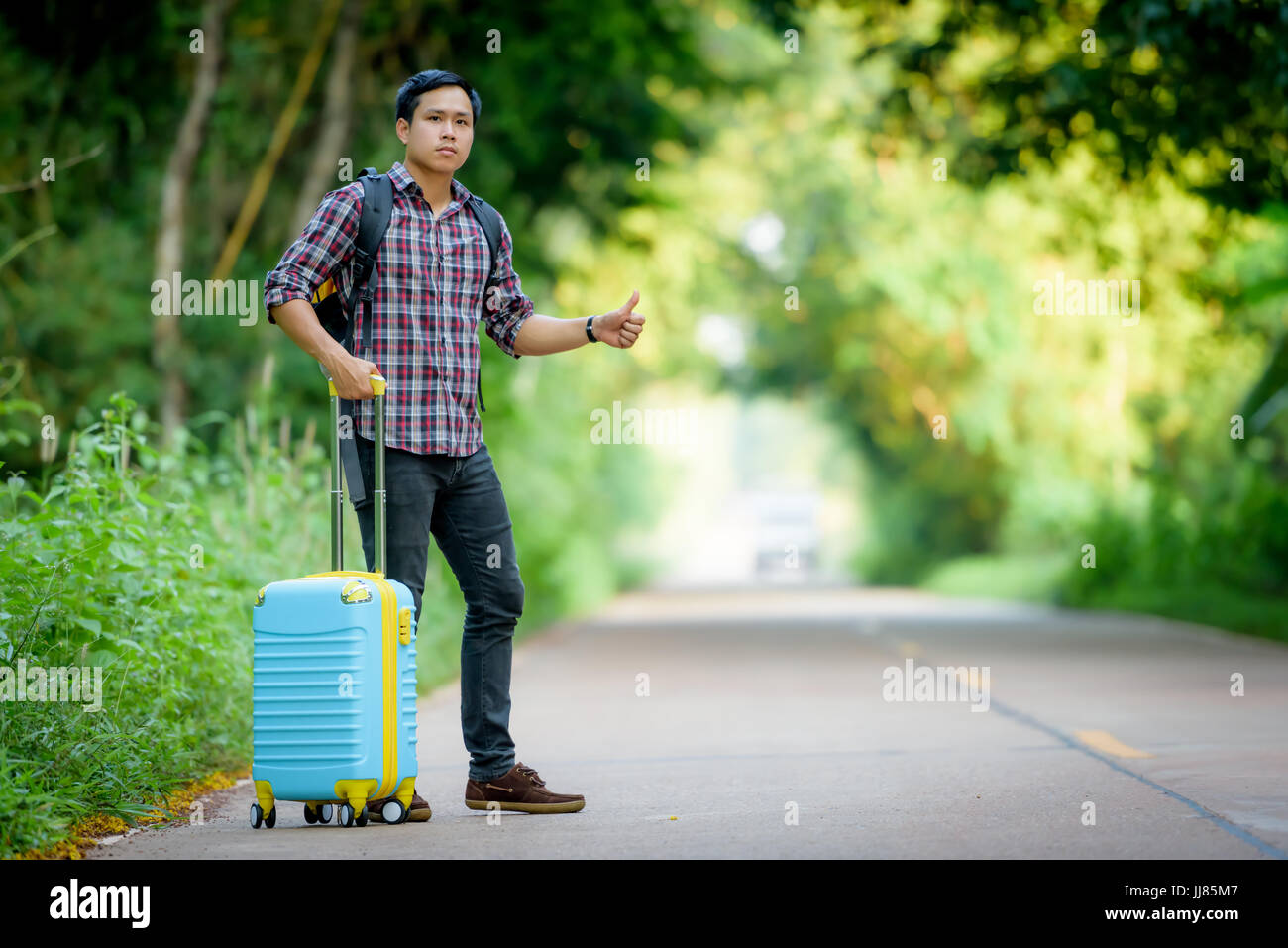 Backpacker is hitchhiking Stock Photo - Alamy