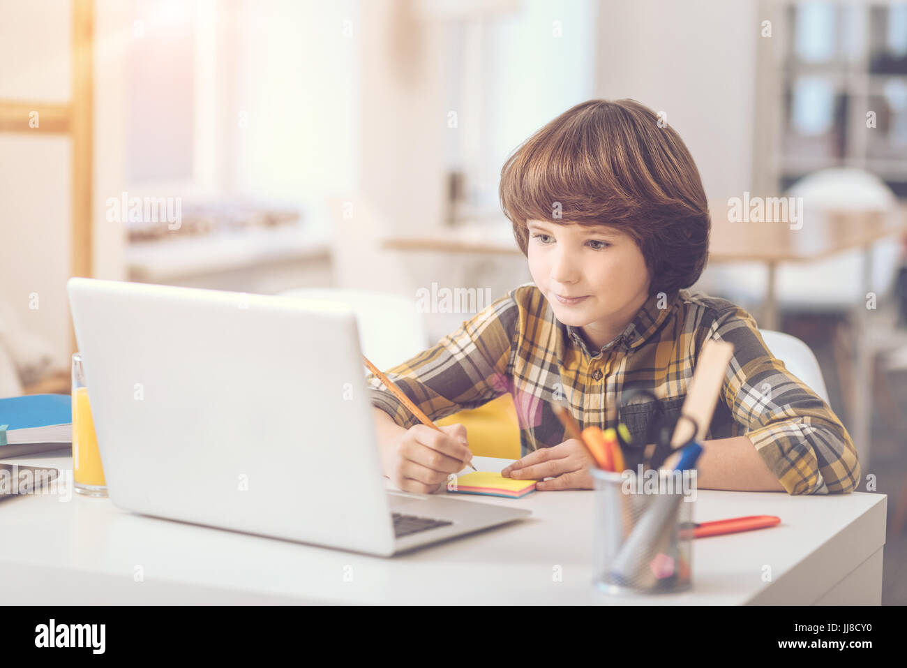 Smart good looking boy writing on sticky notes Stock Photo - Alamy
