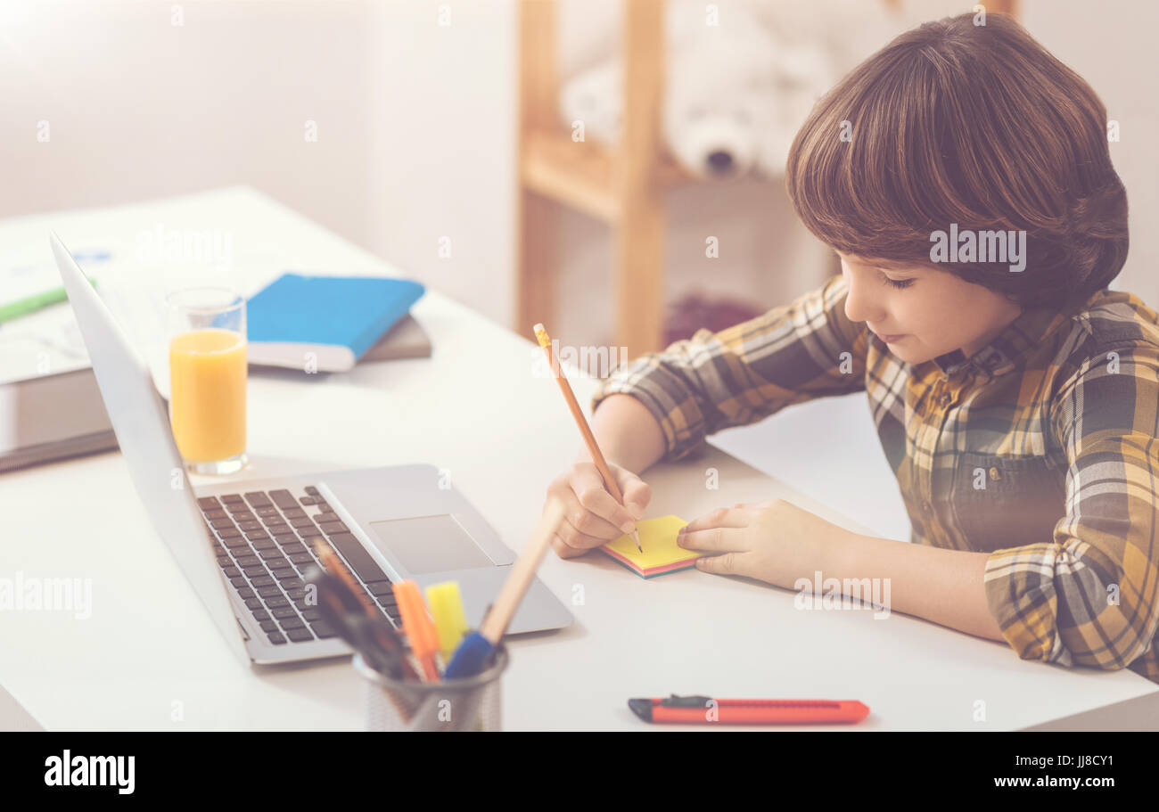 Serious pleasant boy holding a pencil Stock Photo - Alamy