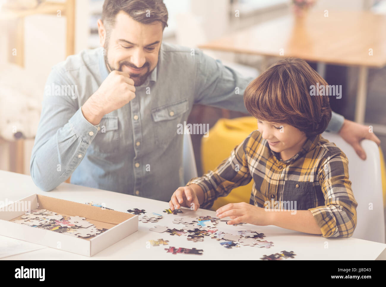 Nice intelligent kid doing a jigsaw puzzle Stock Photo - Alamy