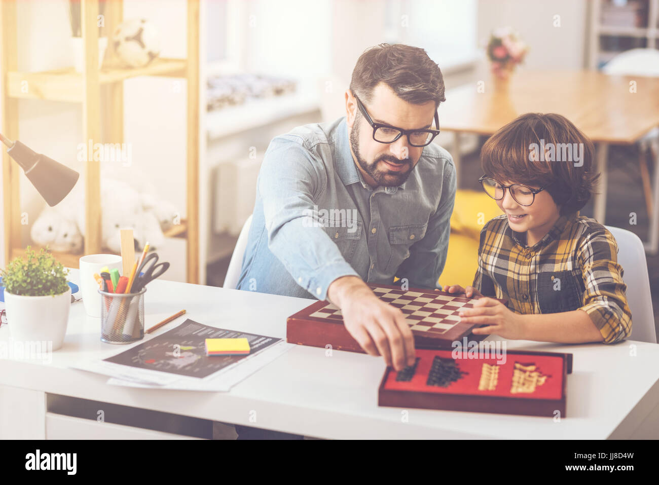 Handsome intelligent man taking chess pieces Stock Photo - Alamy