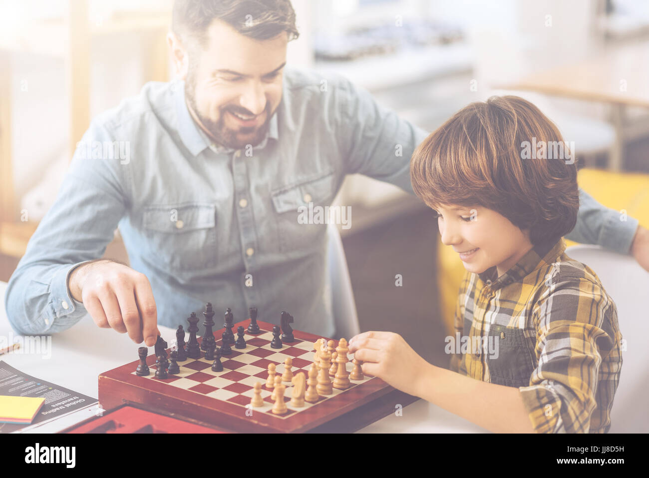 Positive delighted boy doing the first chess move Stock Photo - Alamy