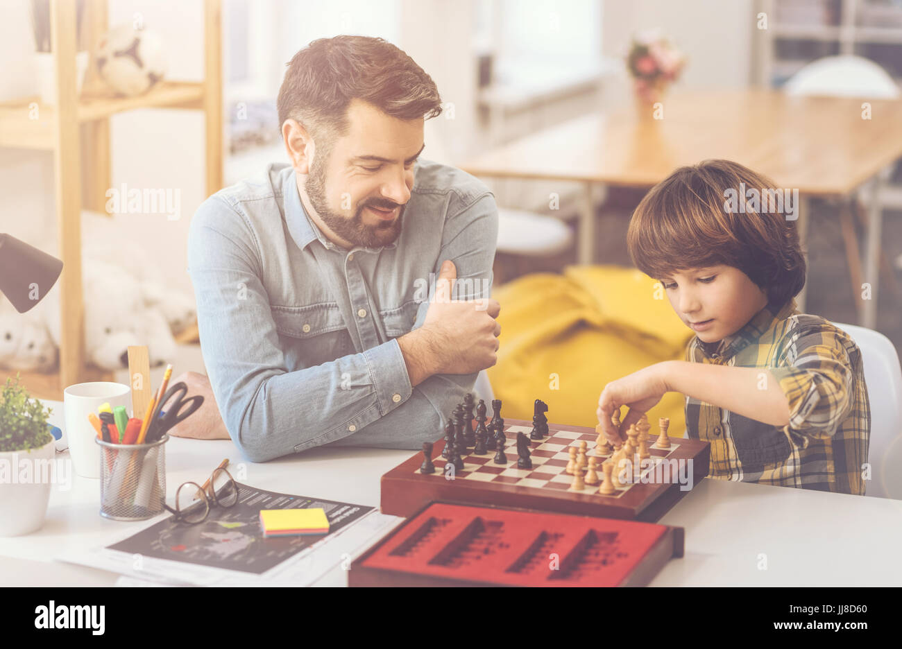 Positive nice father and son playing chess Stock Photo - Alamy