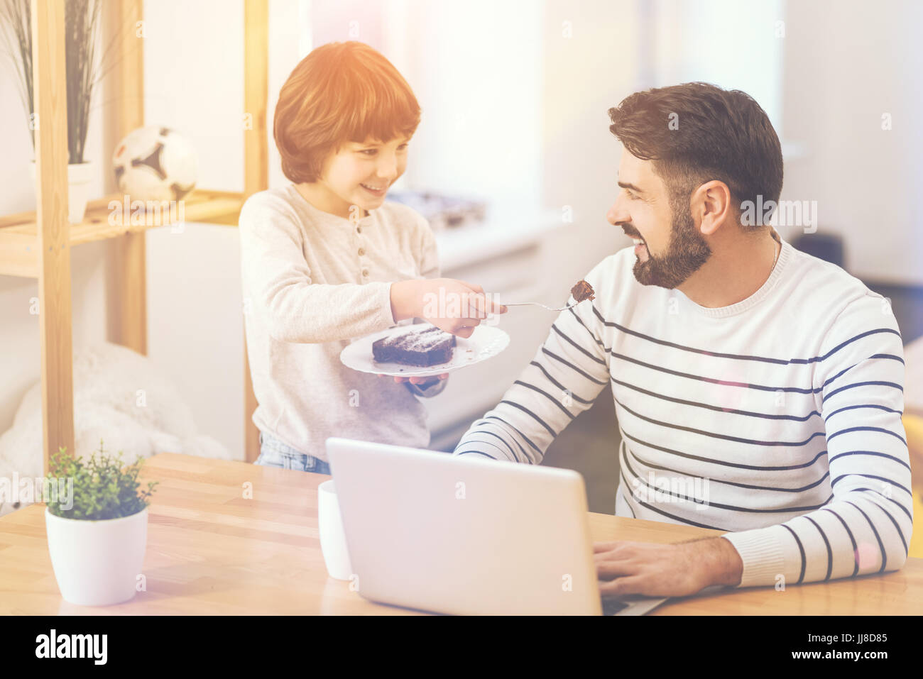 Positive happy boy offering his father a cake Stock Photo - Alamy