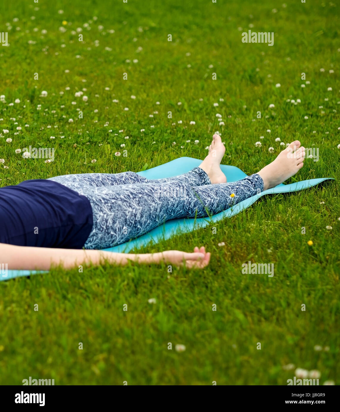 Caucasian woman doing yoga, meditating, Shavasana or corpse position in ...