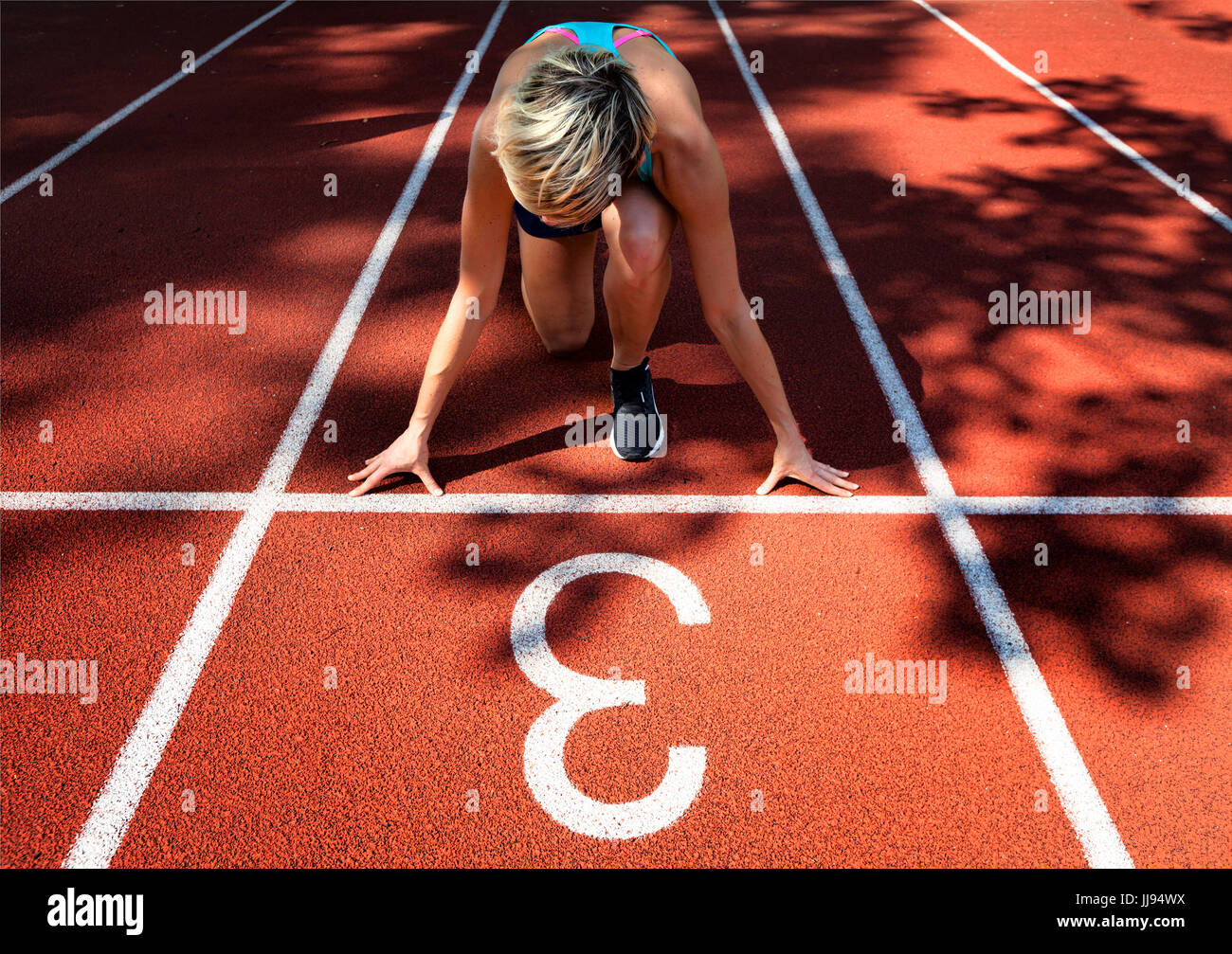 Athlete on starting line waiting for the start in running track Stock ...