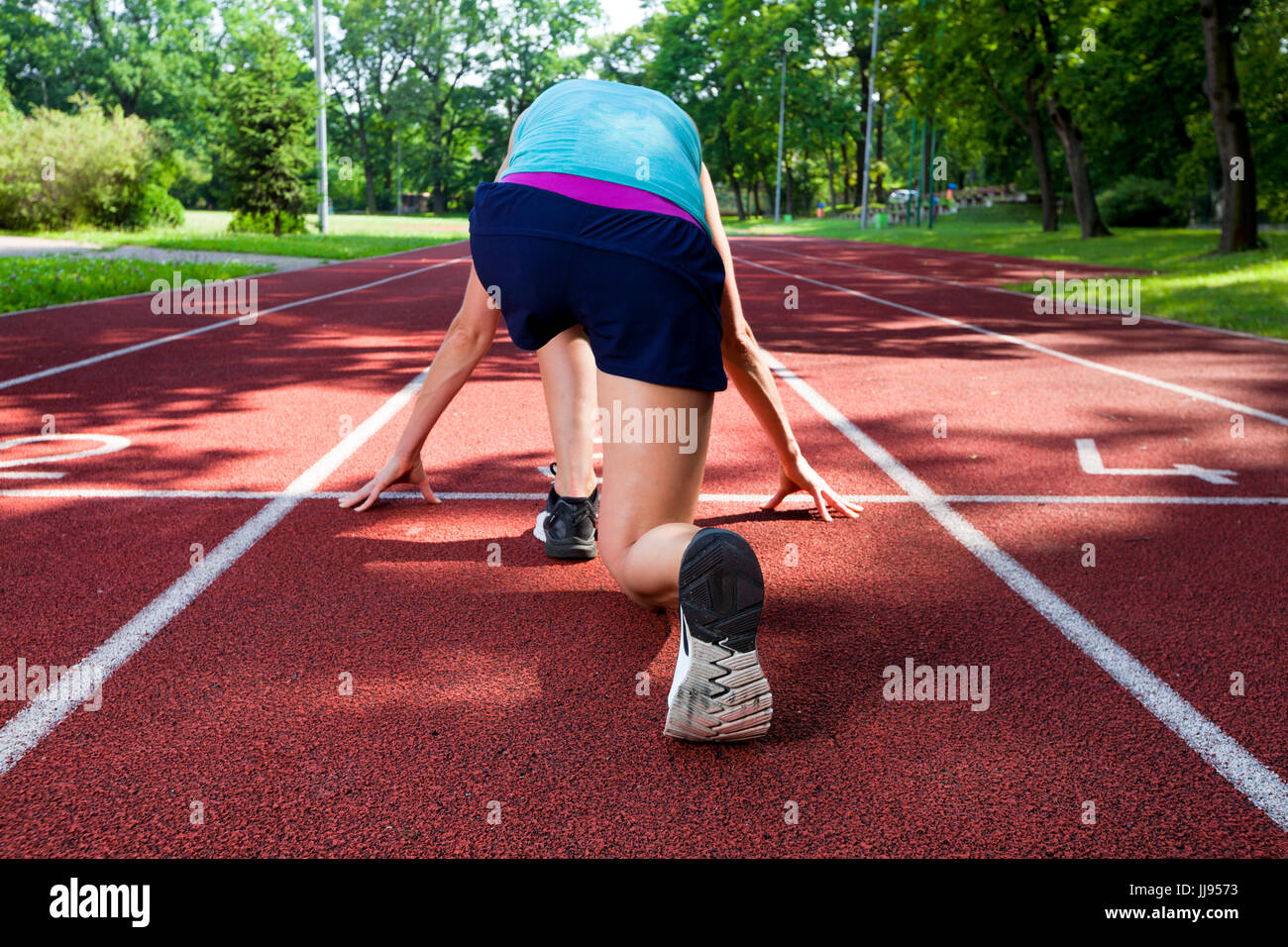 Athlete on starting line waiting for the start in running track Stock ...