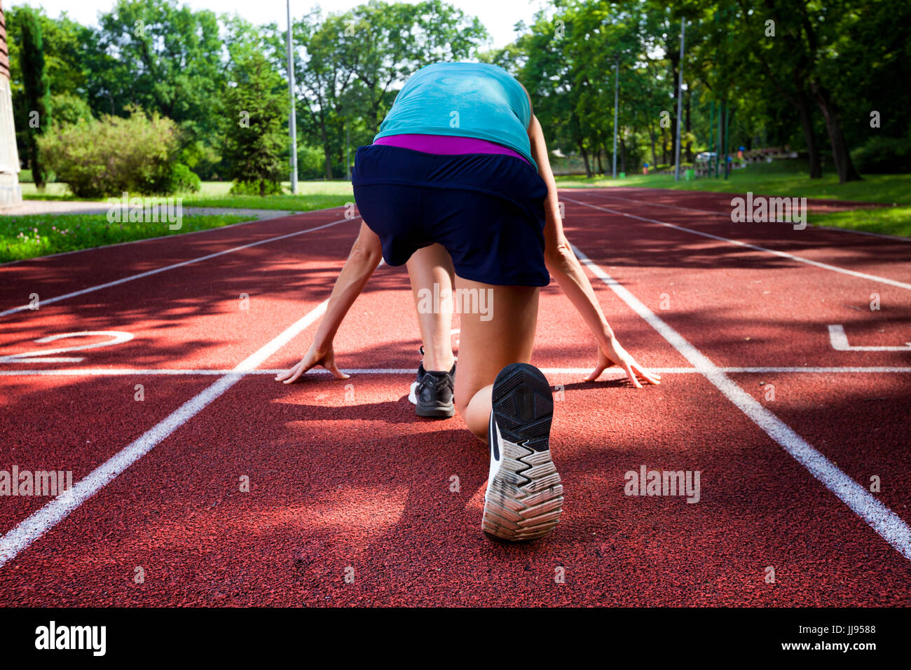 Athlete on starting line waiting for the start in running track Stock ...