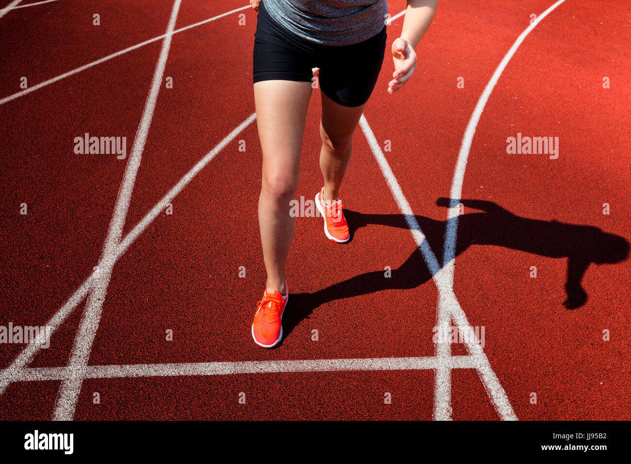 Red running track with female runner, close up on legs Stock Photo - Alamy