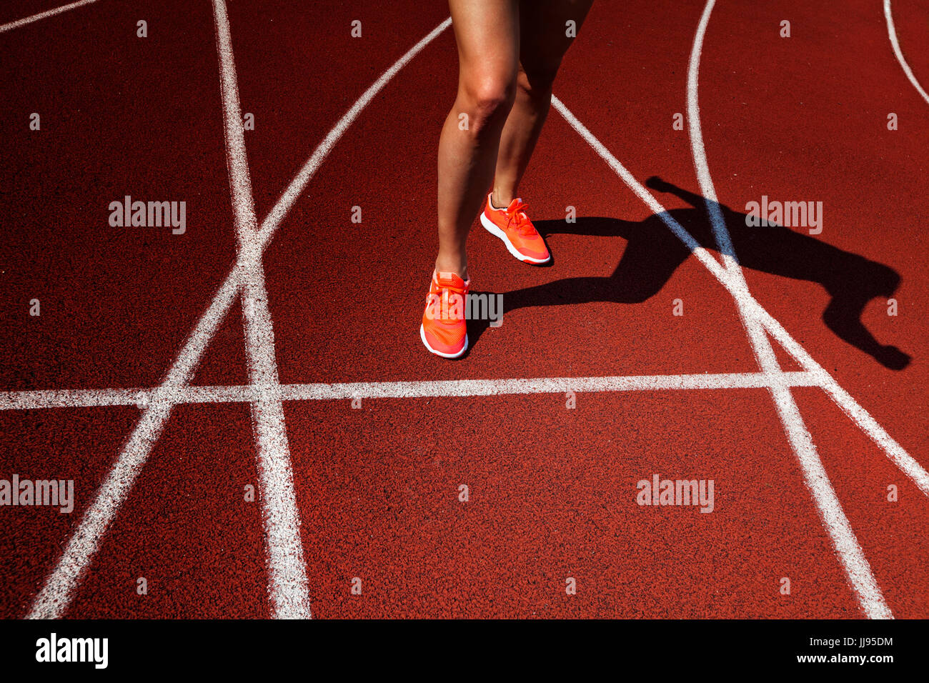Red running track with female runner, close up on legs Stock Photo - Alamy