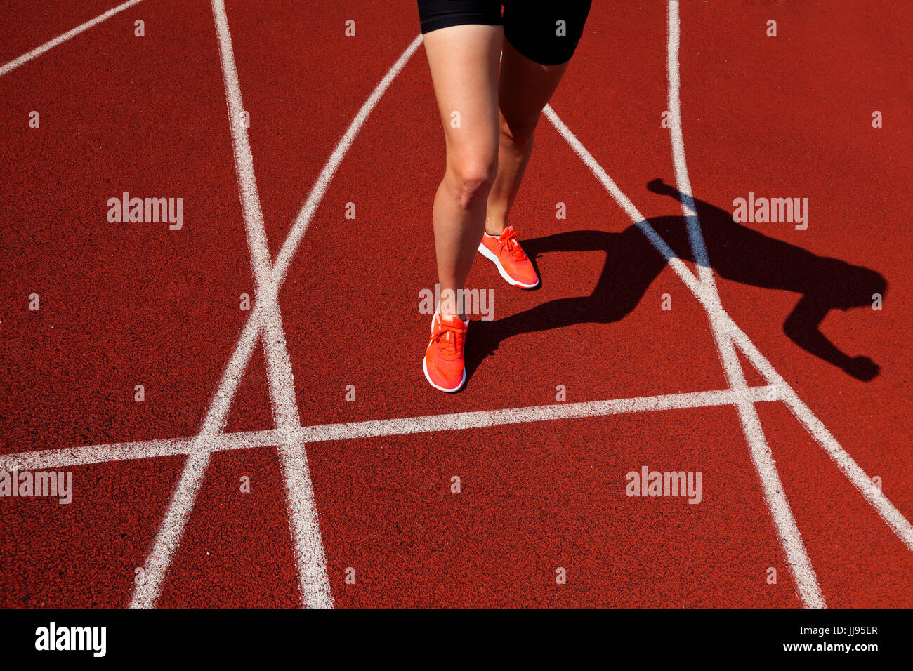 Red running track with female runner, close up on legs Stock Photo - Alamy
