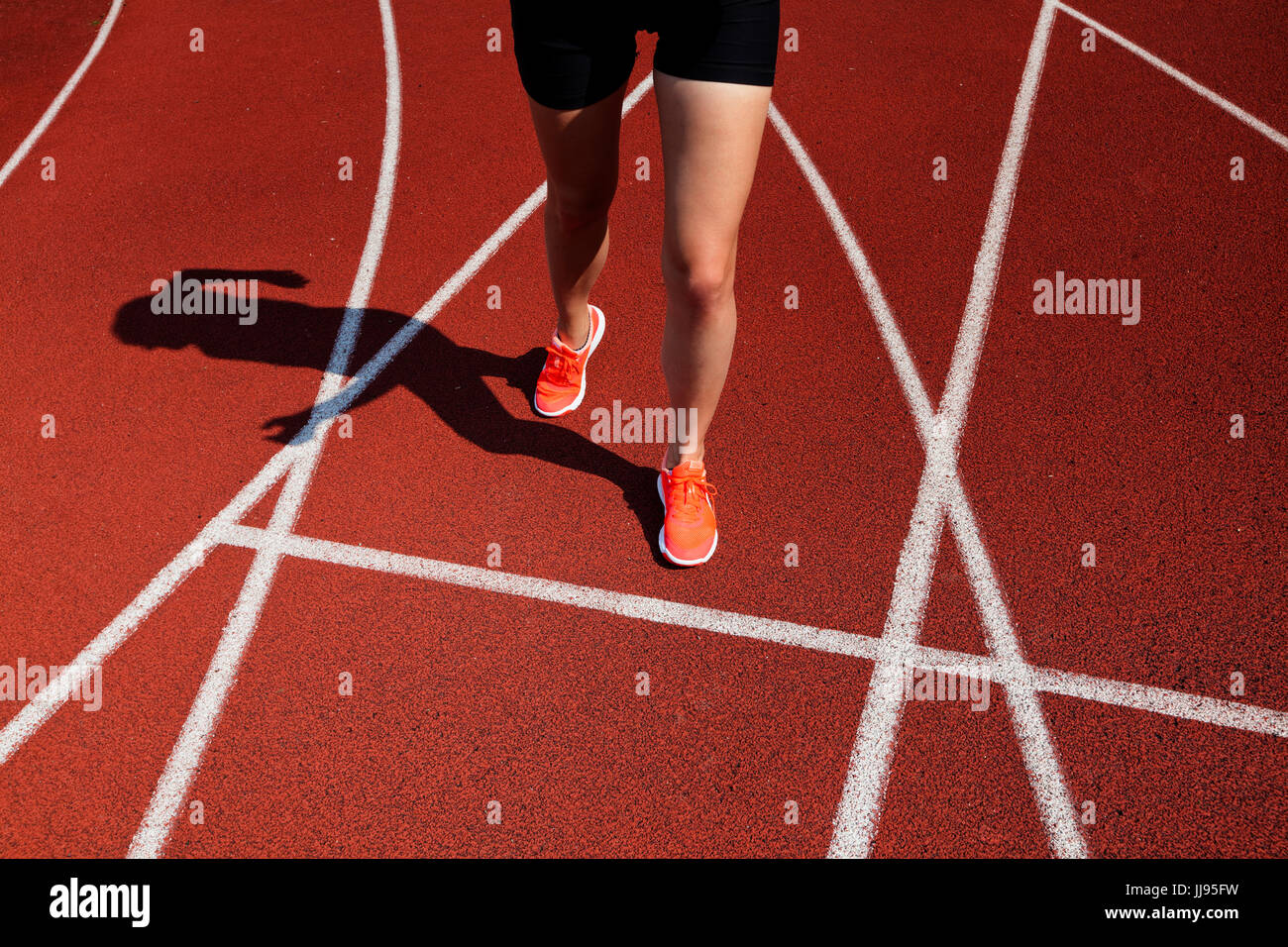 Red running track with female runner, close up on legs Stock Photo - Alamy