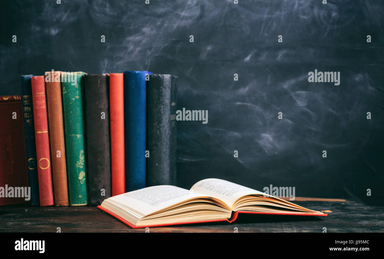 Education concept. Old books on blackboard background Stock Photo - Alamy
