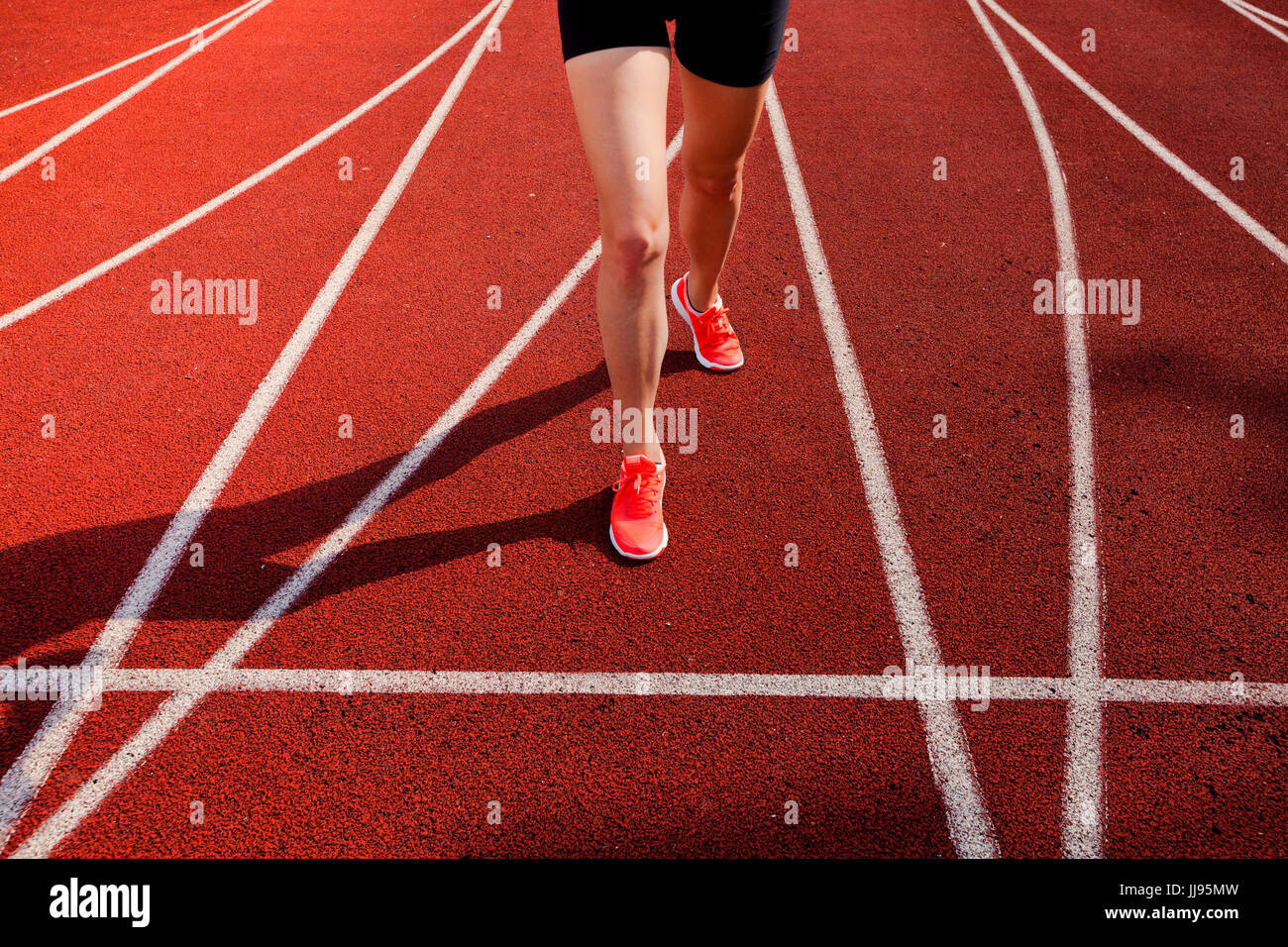 Red running track with female runner, close up on legs Stock Photo - Alamy