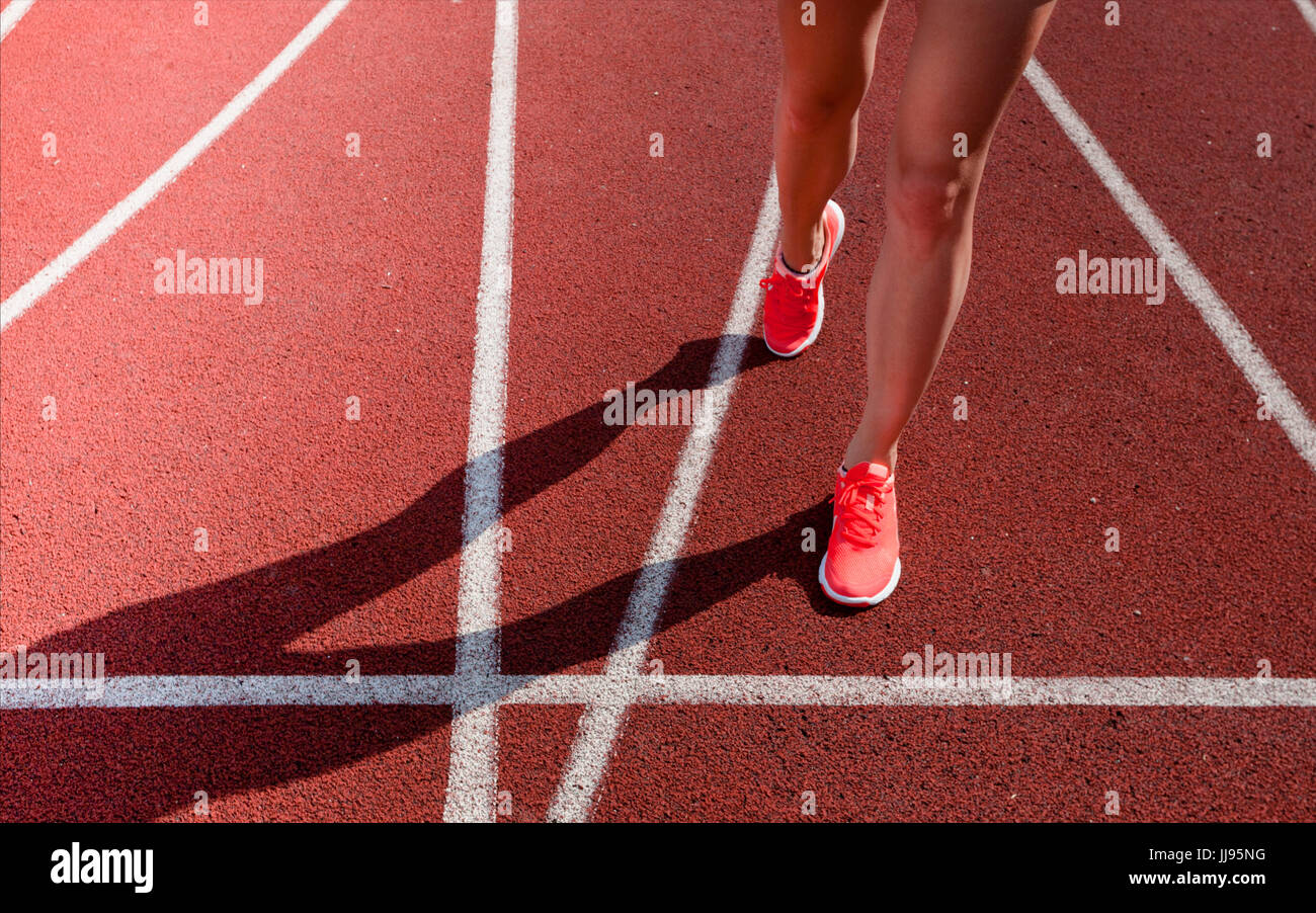 Red running track with female runner, close up on legs Stock Photo - Alamy