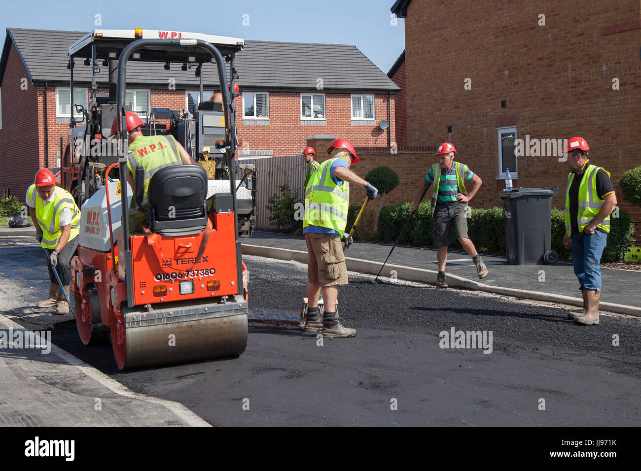 Team laying Tarmac, bitmac, aspahlt and using road roller in a new ...