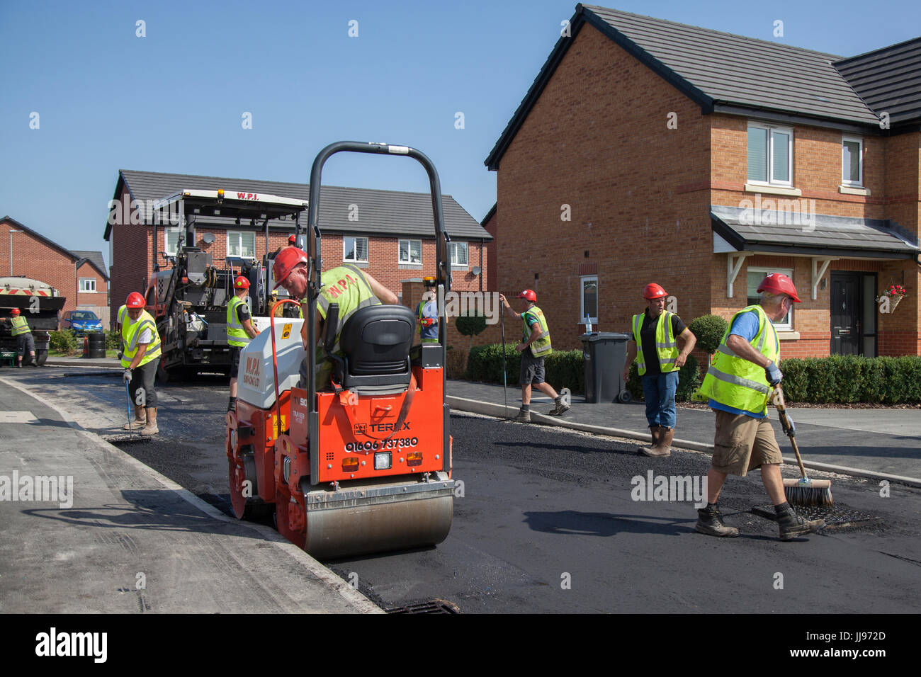 Team laying Tarmac, bitmac, aspahlt and using road roller in a new ...