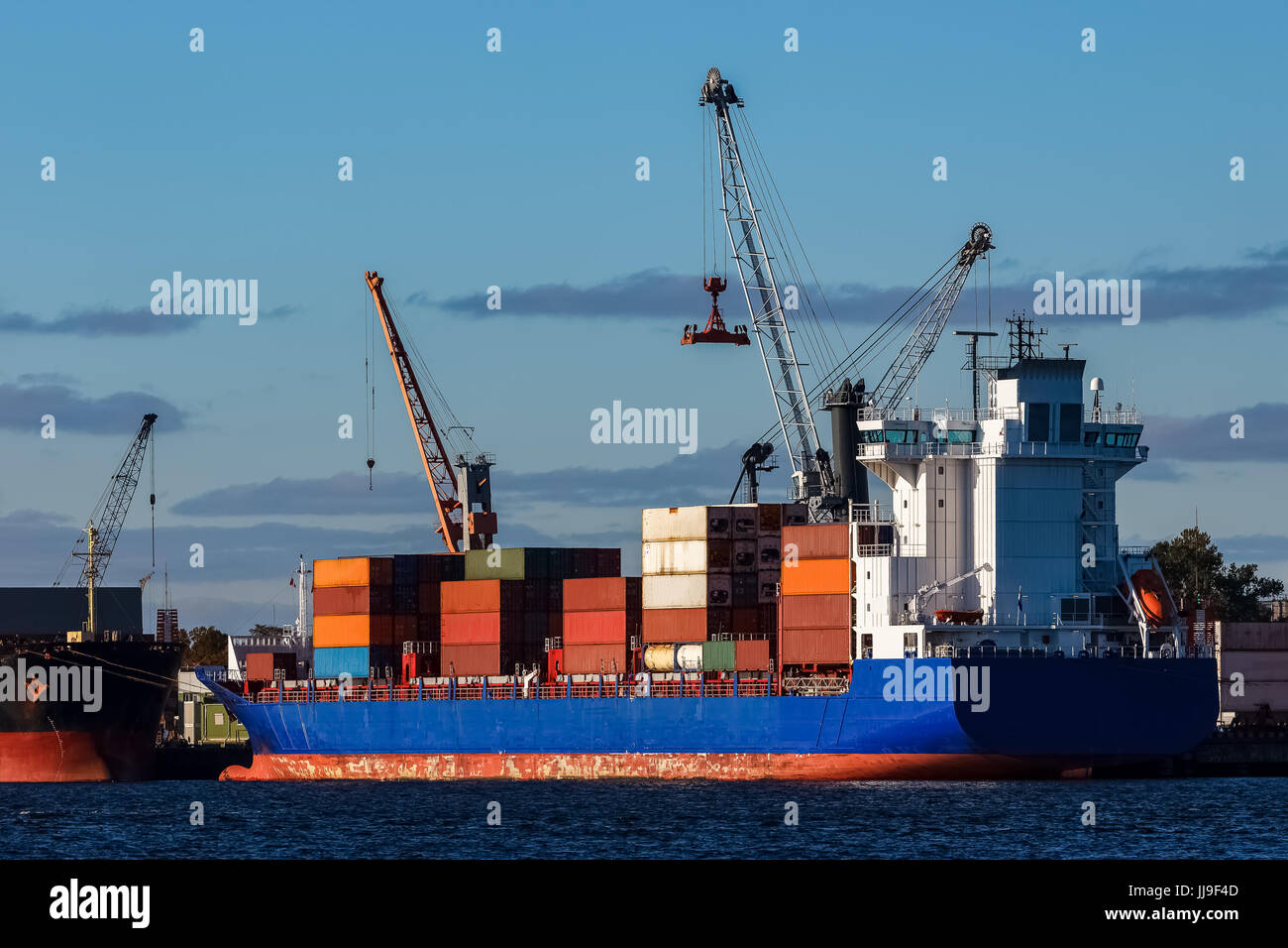 Blue container ship loading in cargo port of Europe Stock Photo - Alamy