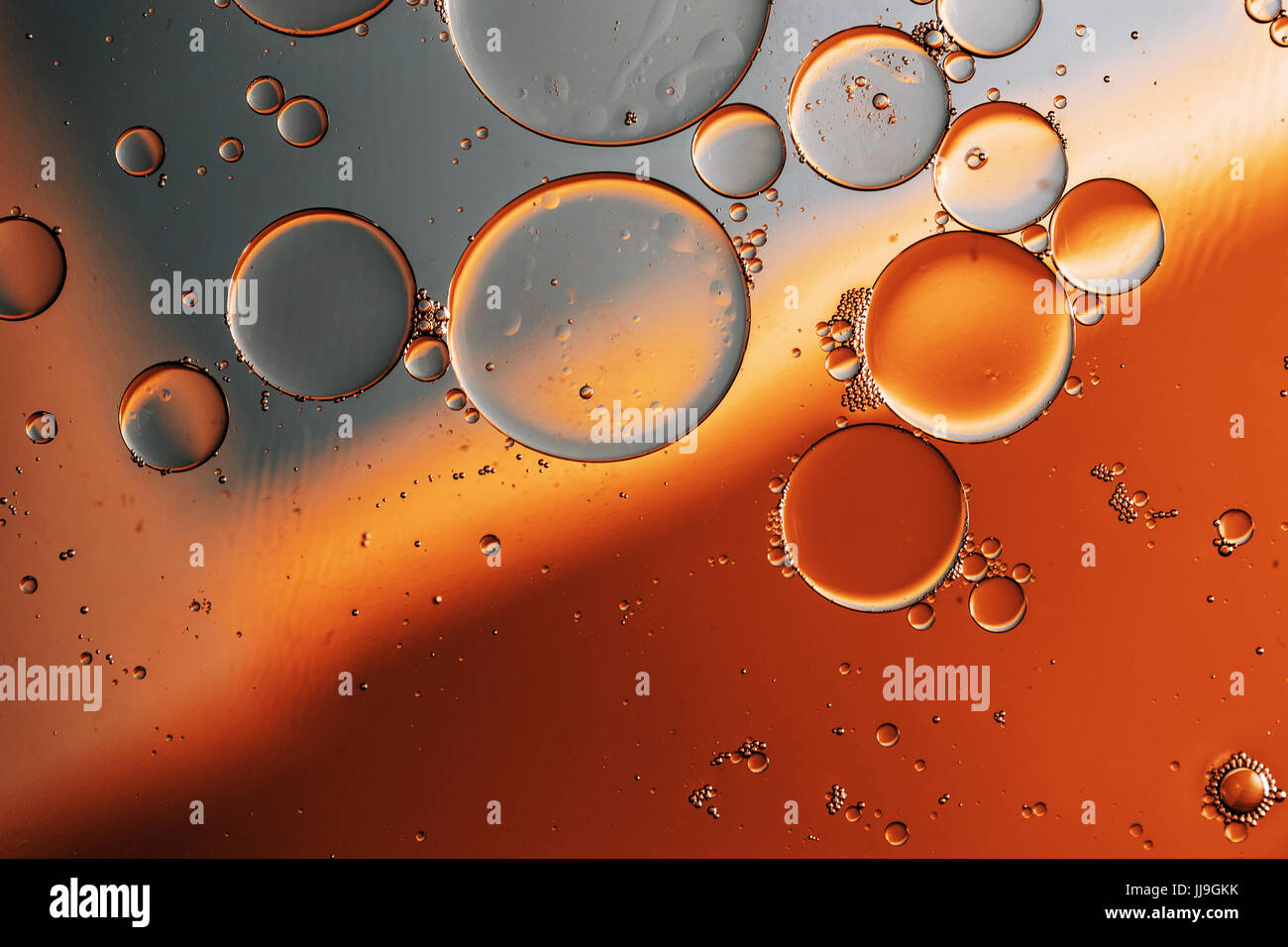 Oil drops on a water surface with color background Stock Photo - Alamy