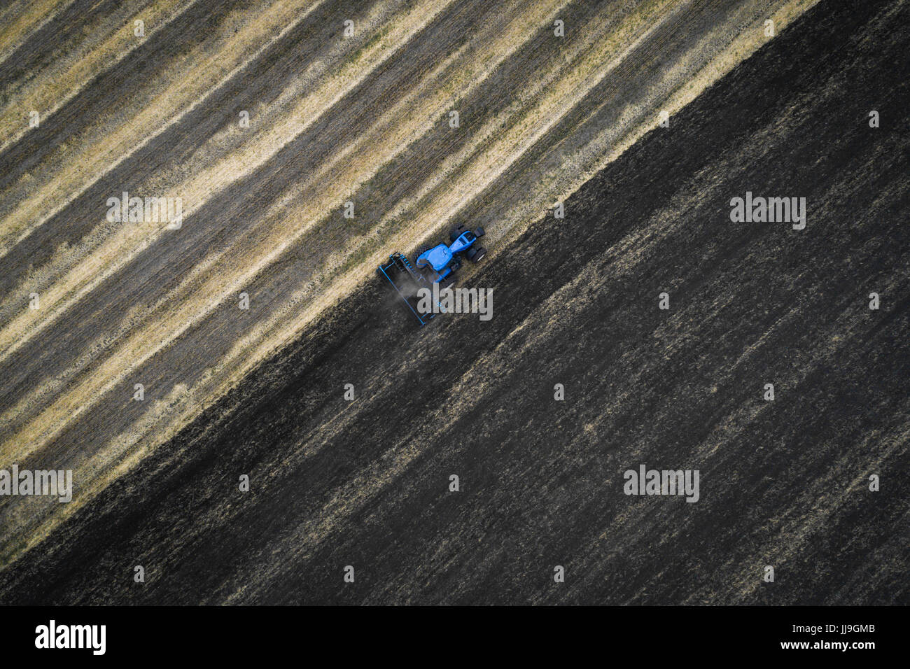 Tractor cultivating field at spring, aerial view Stock Photo - Alamy
