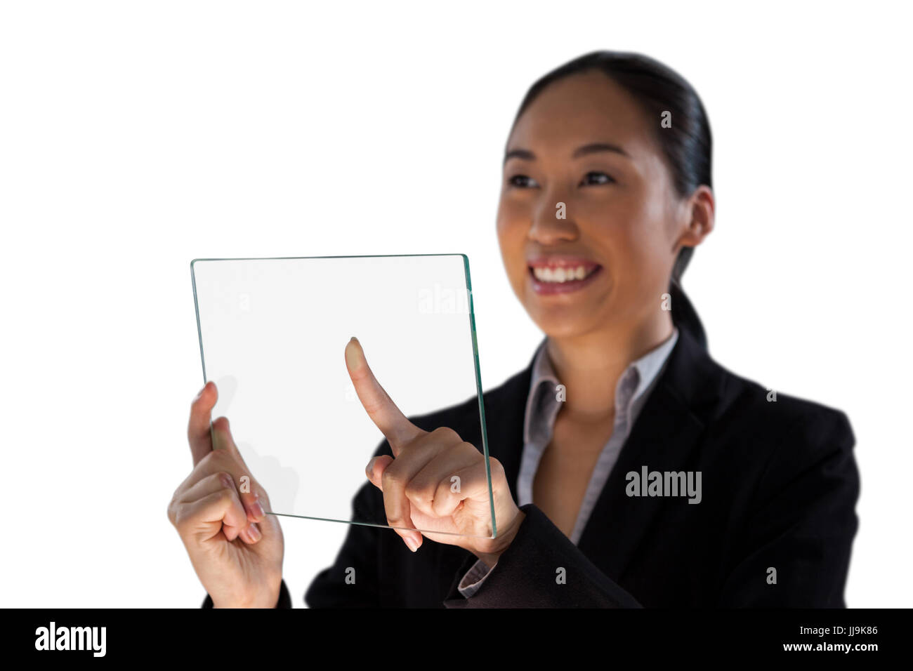 Smiling businesswoman looking away while touching glass interface ...