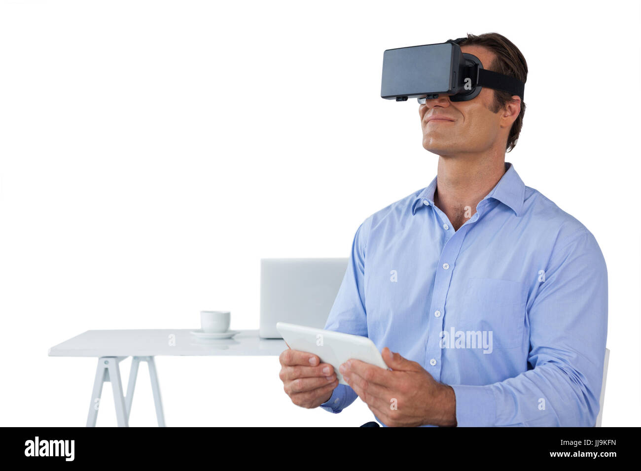 Businessman holding tablet while wearing vr glasses against white ...